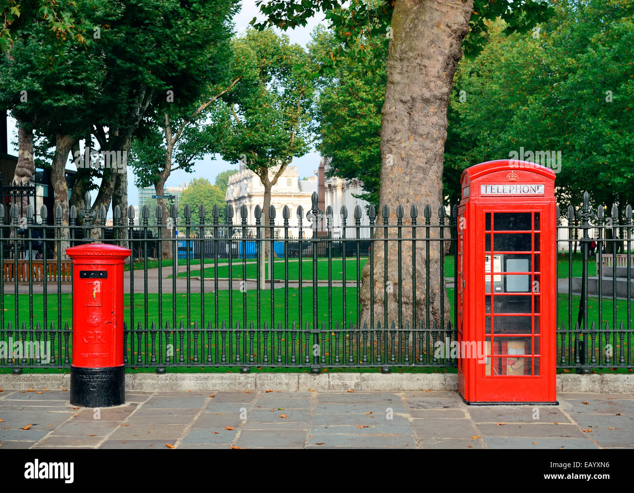 Red telephone and post box in street with historical architecture in ...