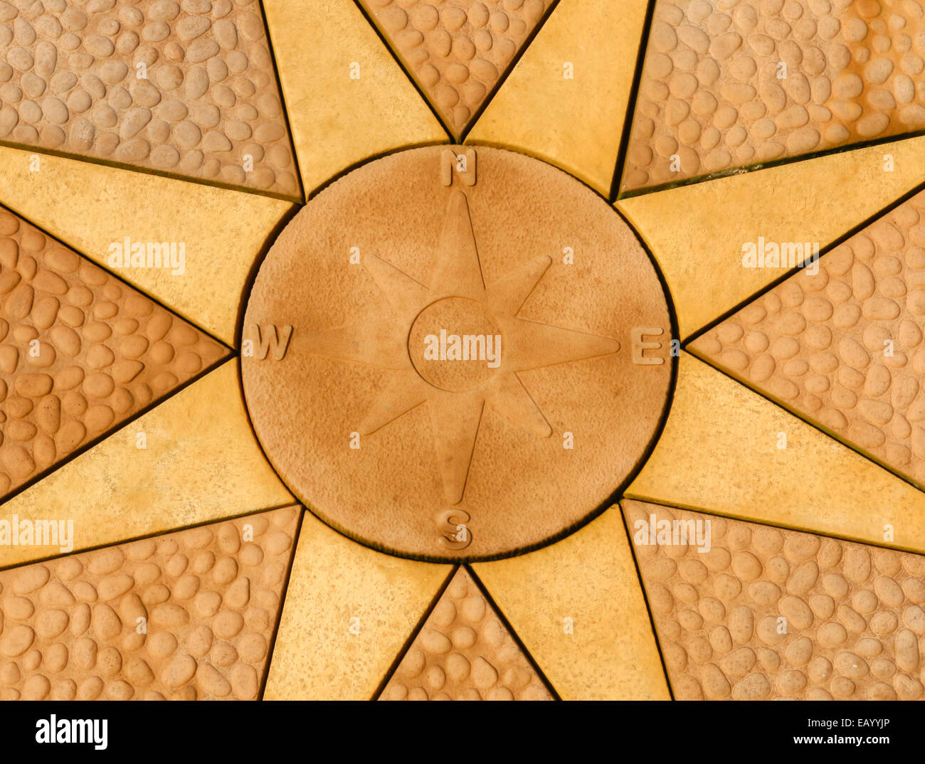 Stone compass rose set within a star. Golden coloured paving slabs ...