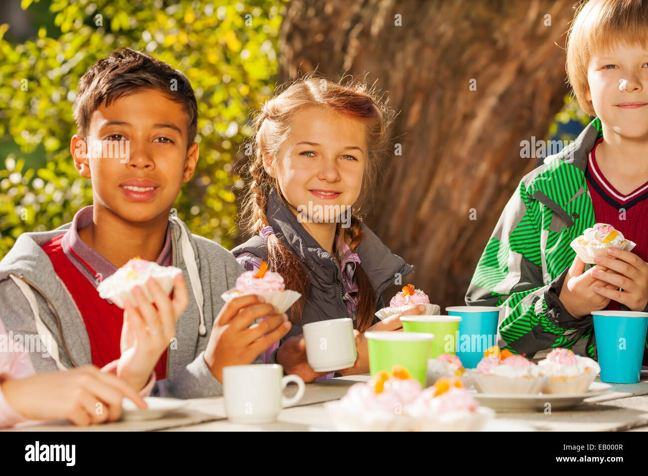 International kids drink tea with cupcakes Stock Photo - Alamy