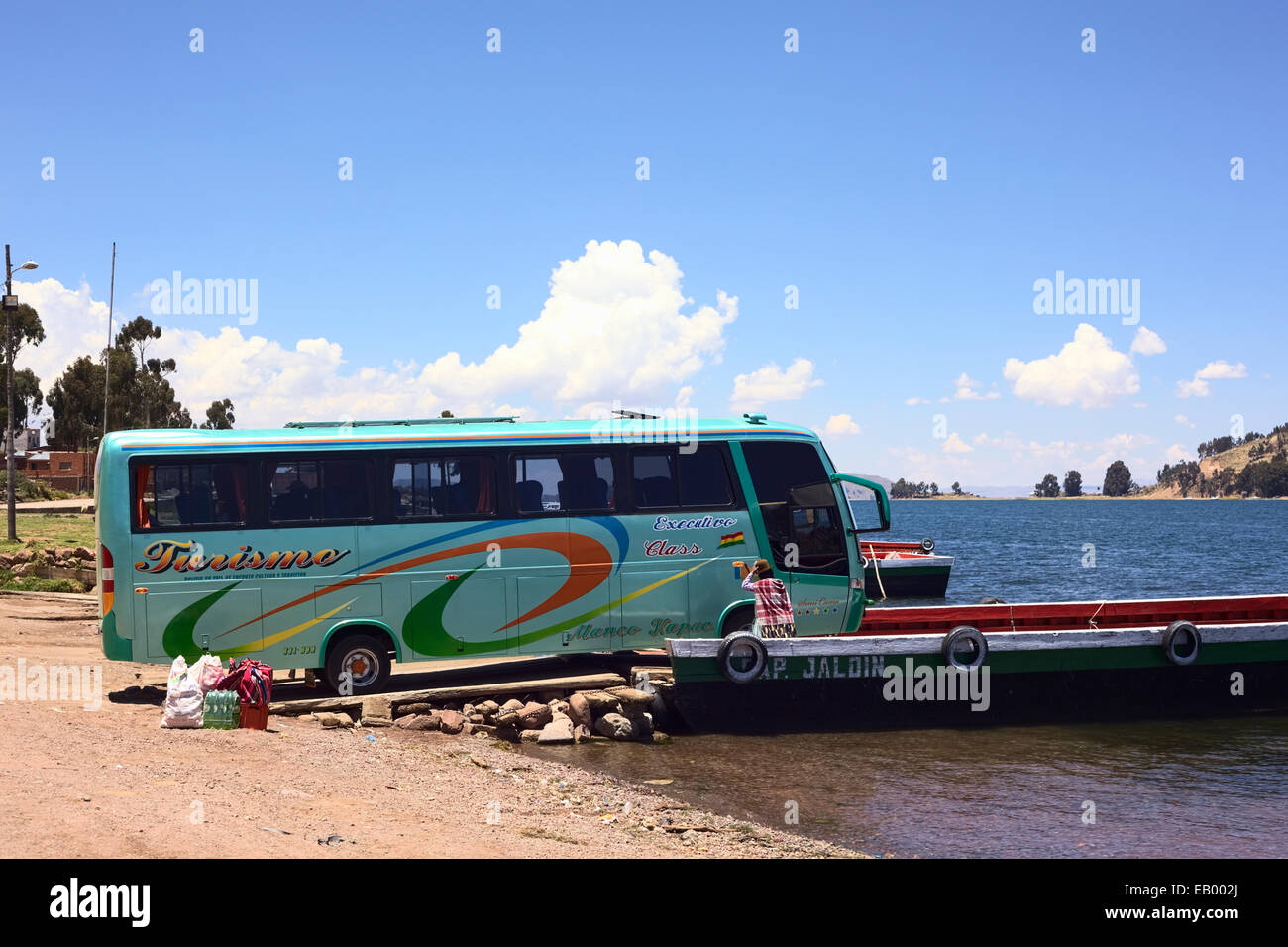 Bus leaving a wooden ferry on the shore of Lake Titicaca at the Strait ...