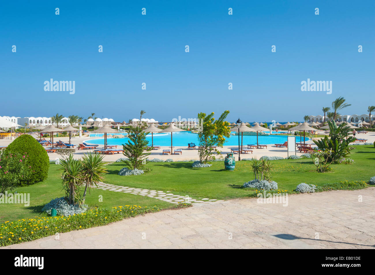 View over a large luxury tropical resort swimming pool with gardens ...