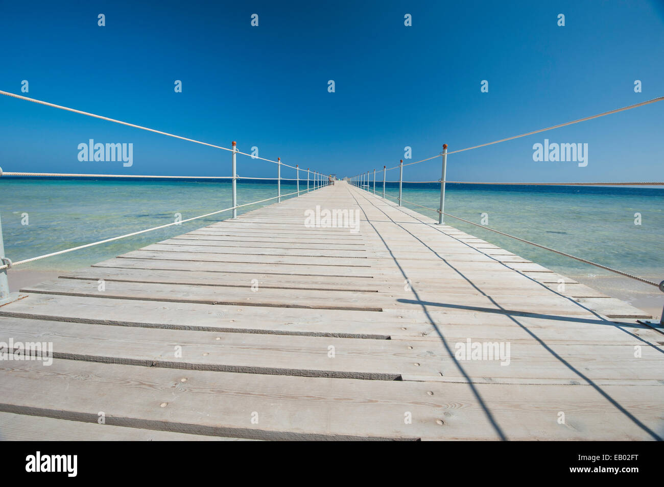 Wooden jetty structure going out to sea on tropical beach resort Stock ...