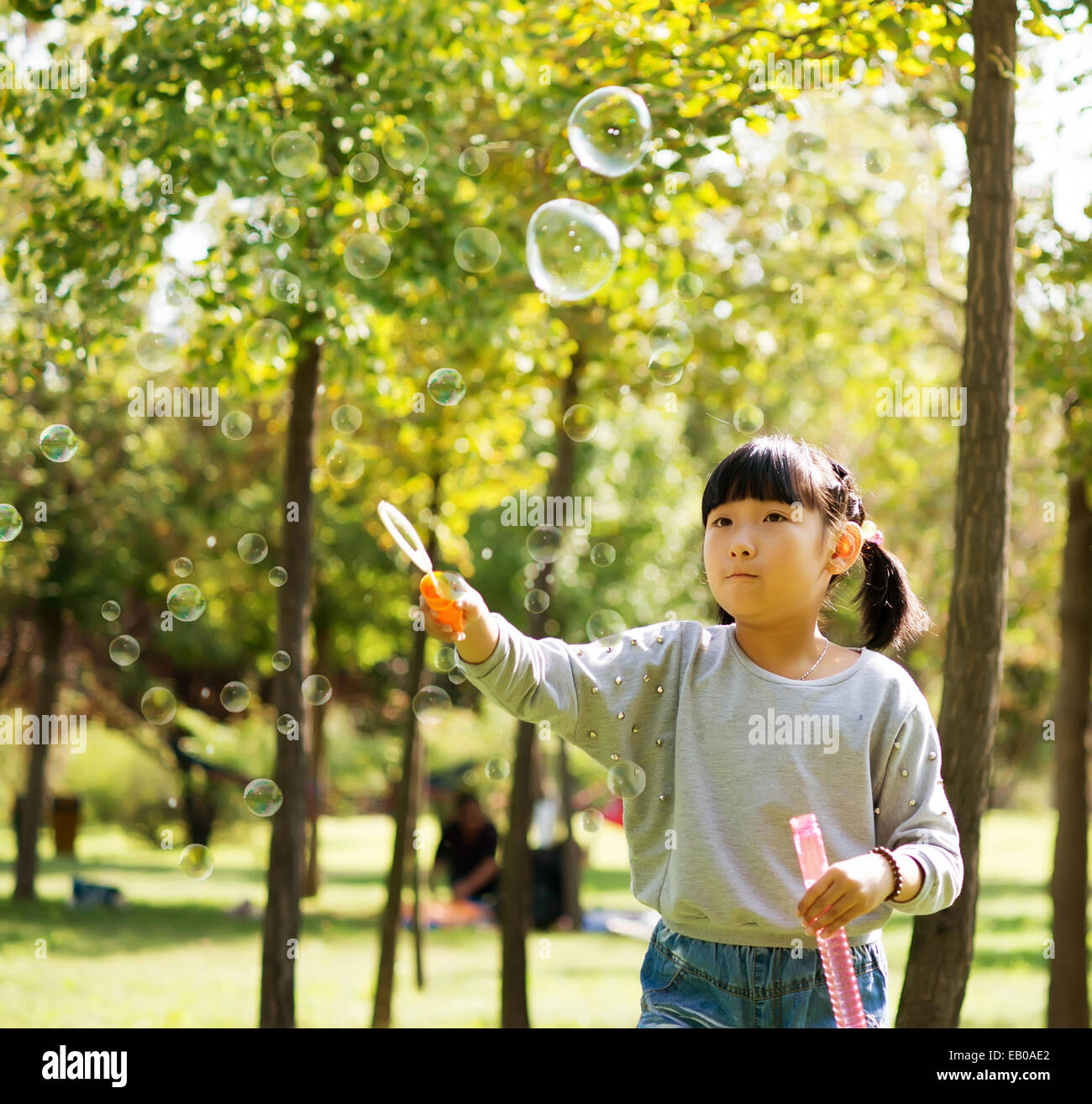 Portrait of a little girl blowing soap bubbles at the park Stock Photo ...