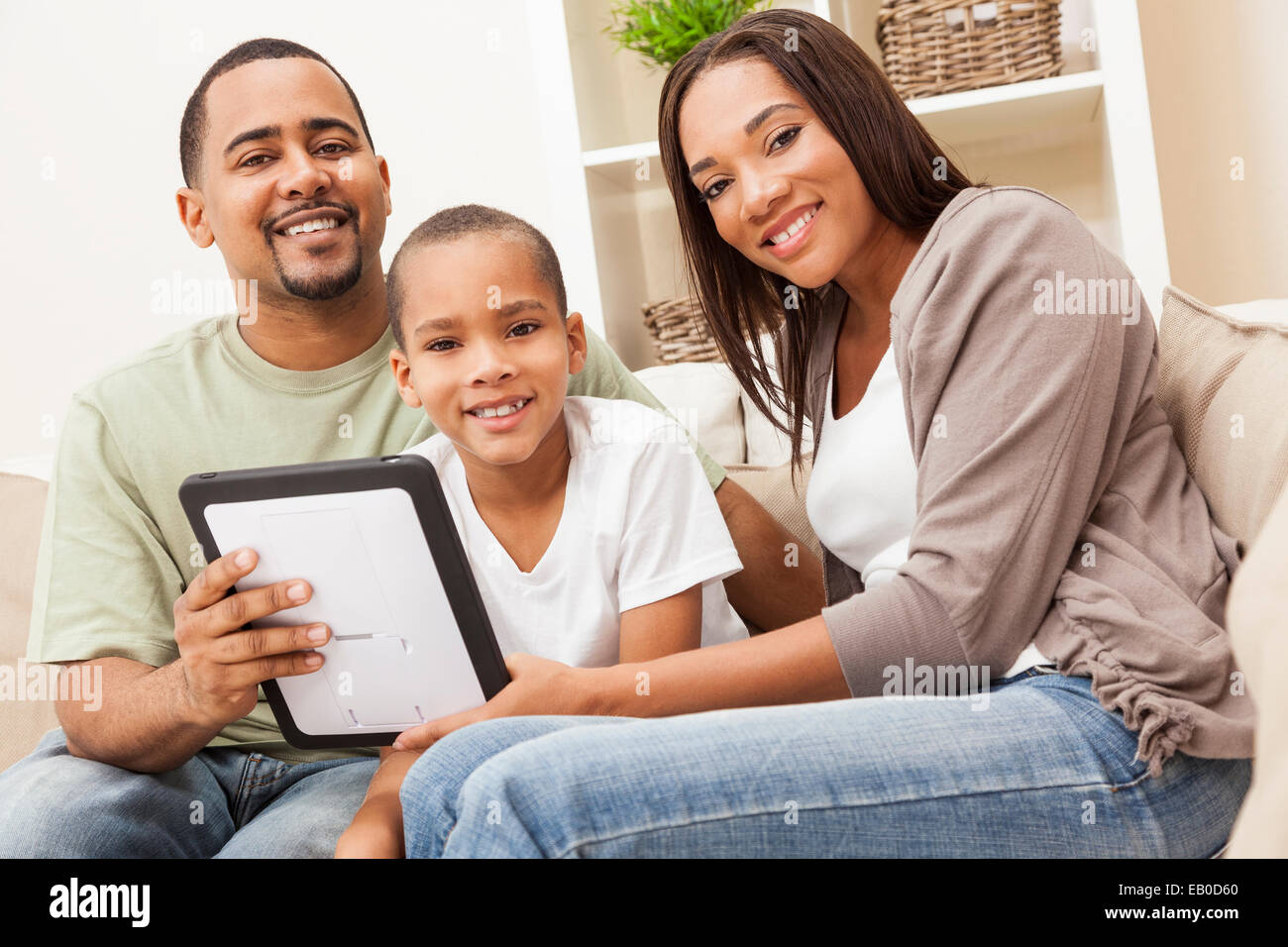 African American family, parents and son, having fun using tablet ...