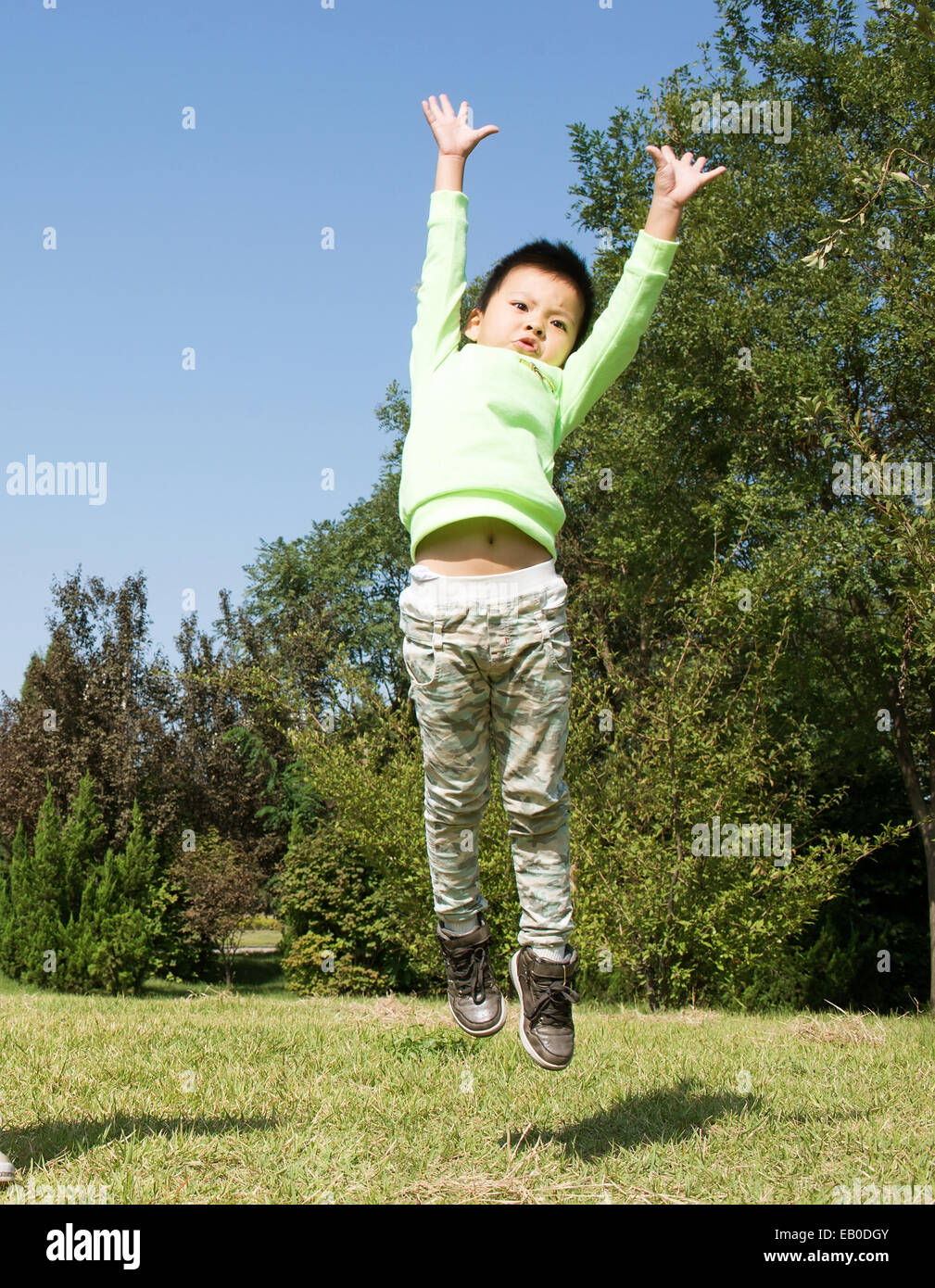 The boy jumps in the outdoor park on the grass Stock Photo - Alamy