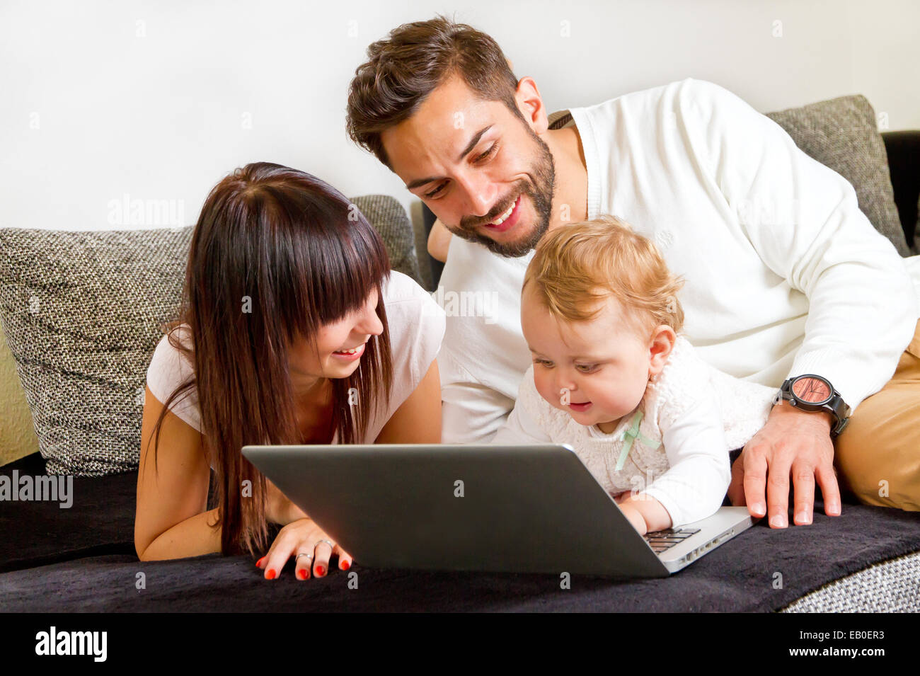 Young family at home on laptop Stock Photo - Alamy
