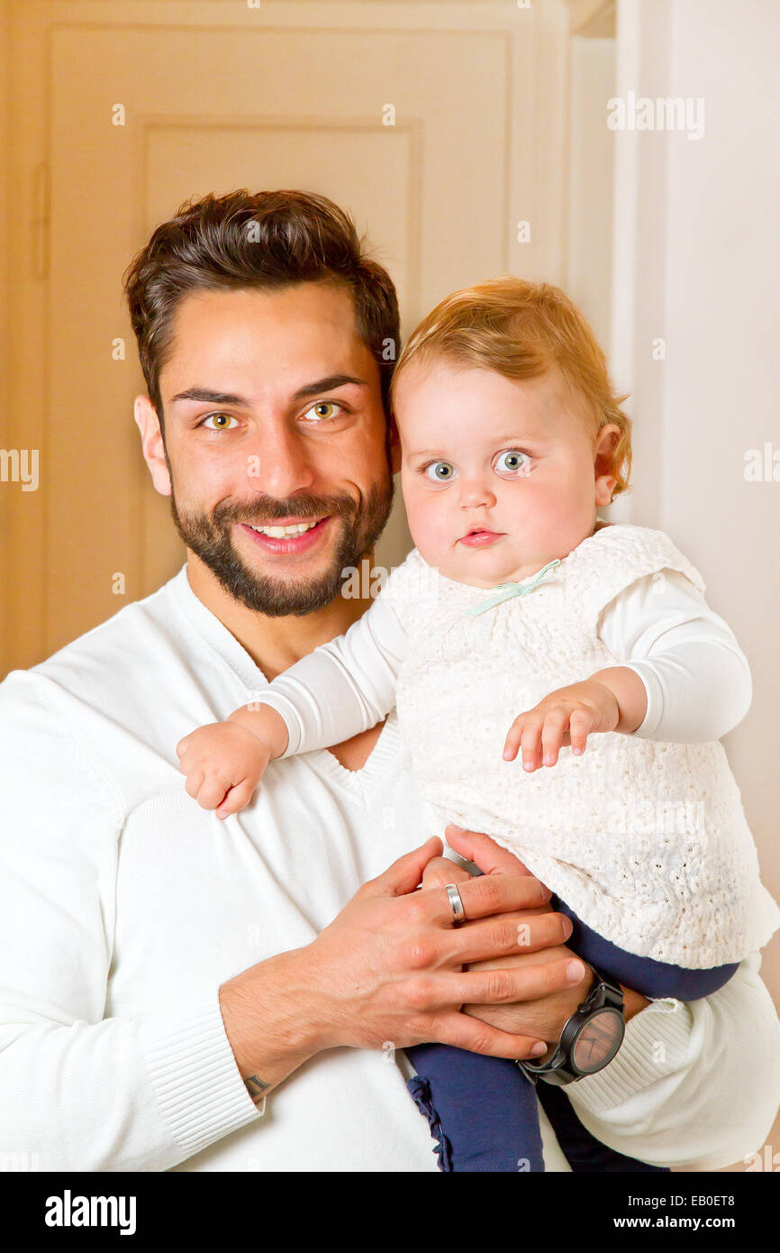 Proud father holding his baby daughter in his at home Stock Photo - Alamy
