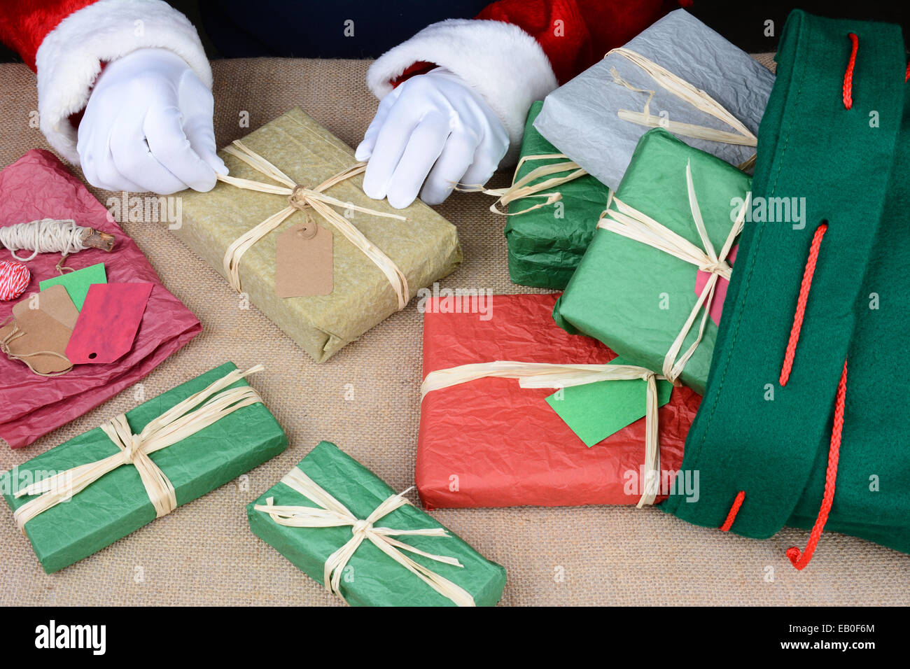 Closeup of Santa Claus wrapping presents. Only Santa's hands are ...