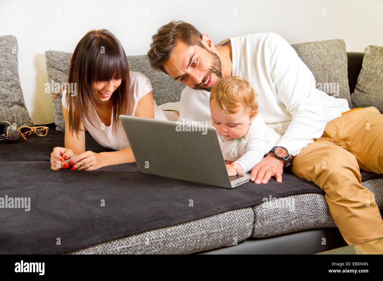 Young family together on laptop Stock Photo - Alamy