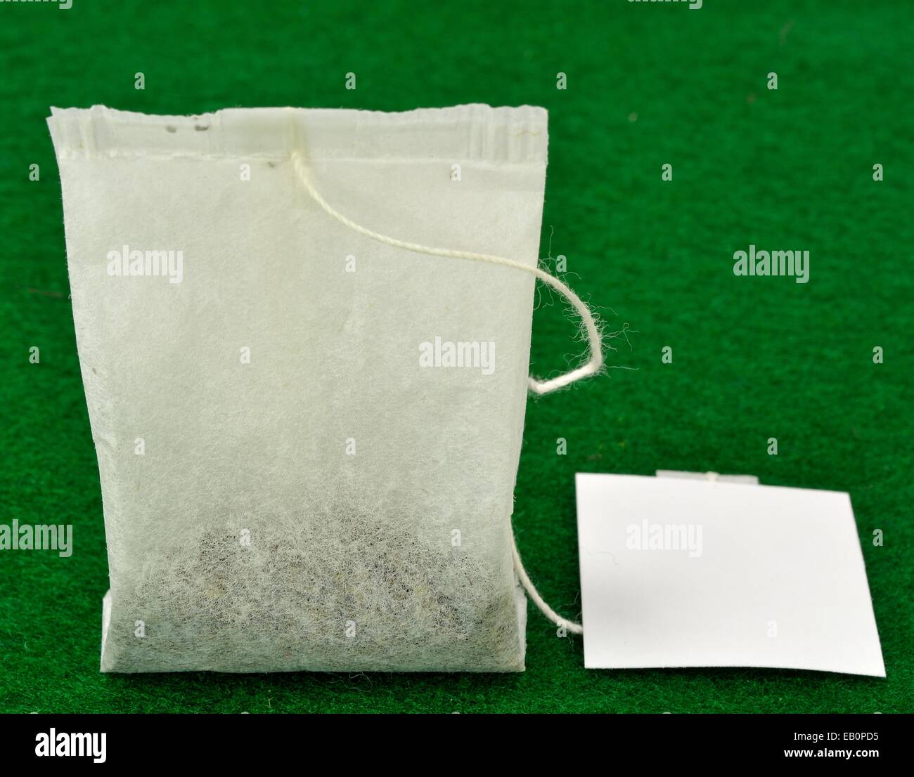 Single tea bag on a green background Stock Photo - Alamy