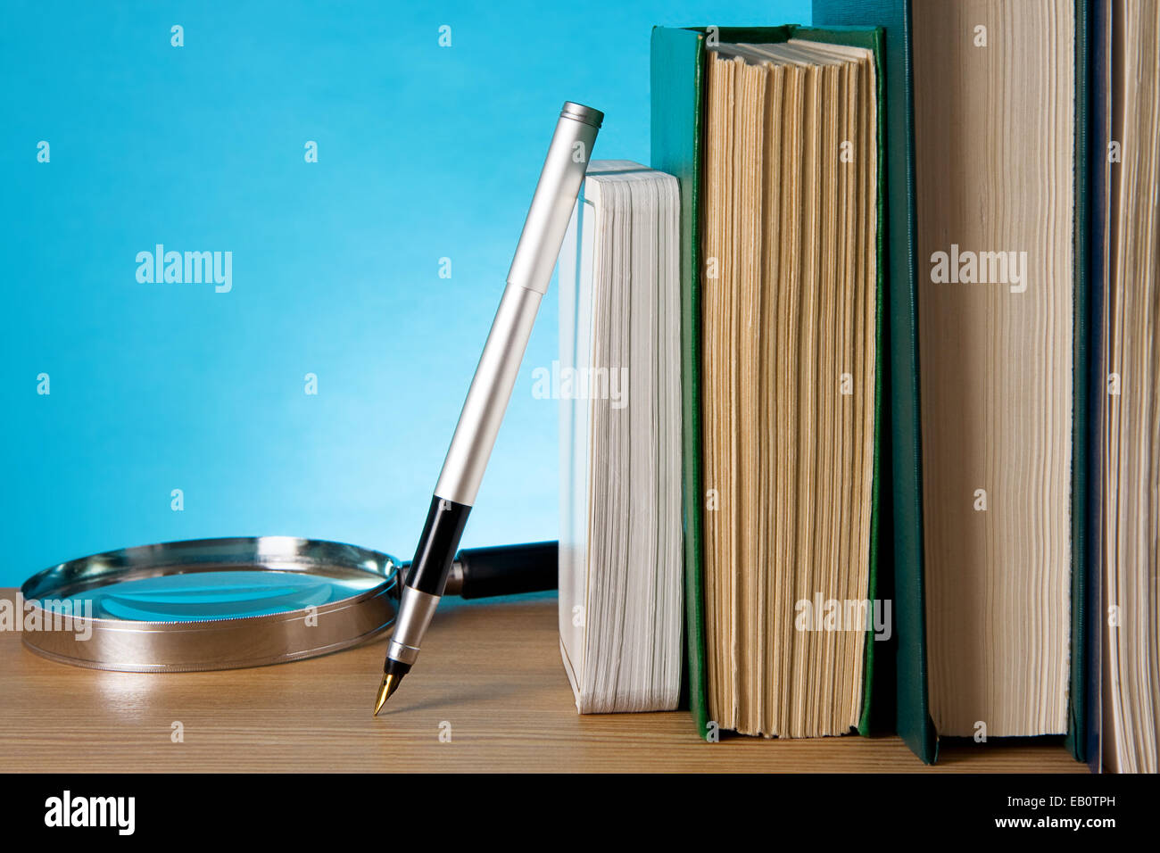 books, magnifier and ink pen on wood table Stock Photo - Alamy