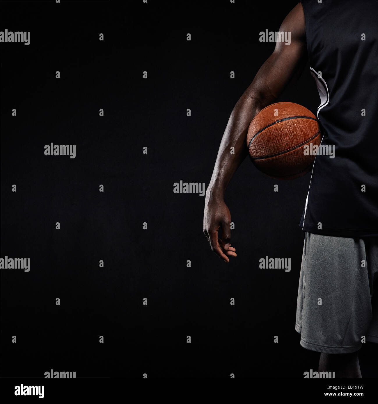 Cropped image of black basketball player standing with a basket ball ...