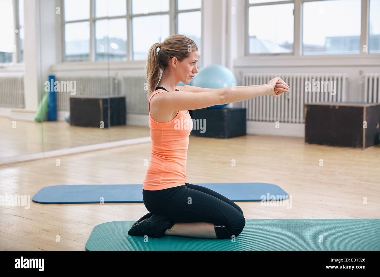Side view fitness woman in gym exercising on workout mat. Caucasian ...