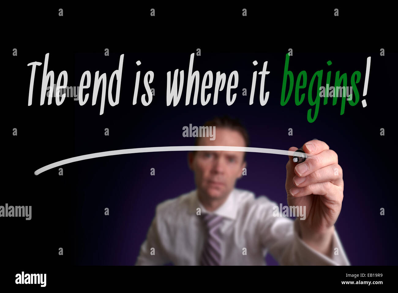 A businessman writing The End Is Where It Begins on a screen. Business ...