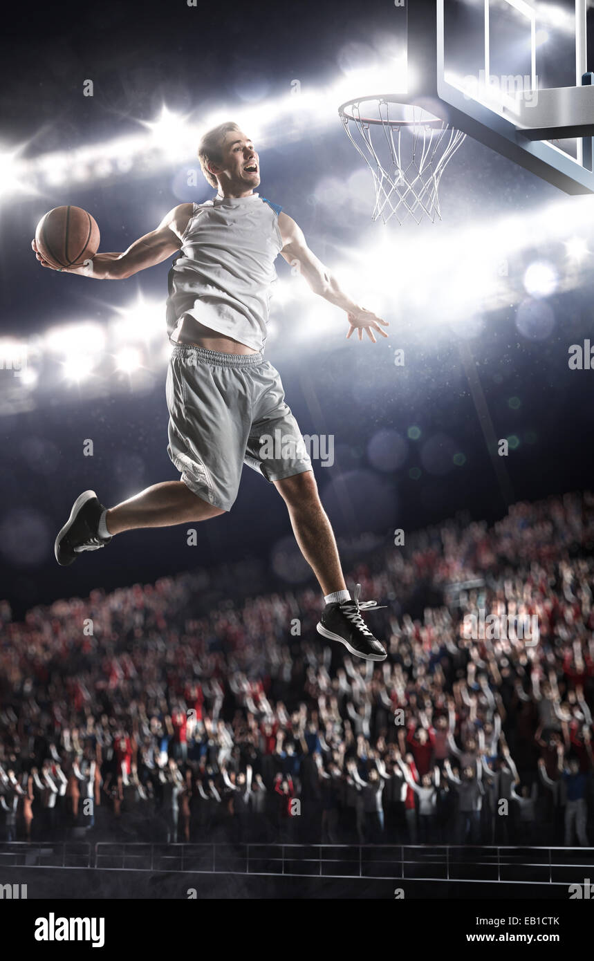 Basketball player in action is flying high and scoring Stock Photo - Alamy