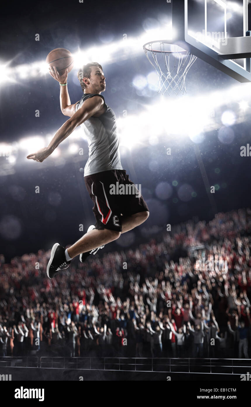 Basketball player in action is flying high and scoring Stock Photo - Alamy