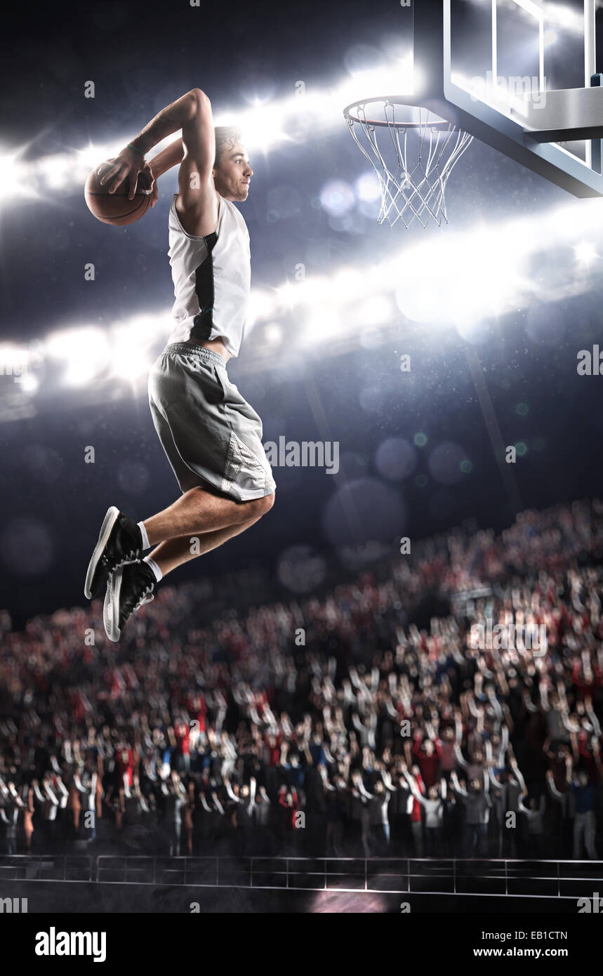 Basketball player in action is flying high and scoring Stock Photo - Alamy