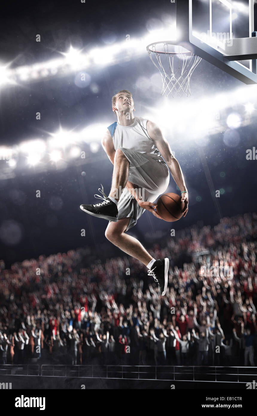 Basketball player in action is flying high and scoring Stock Photo - Alamy