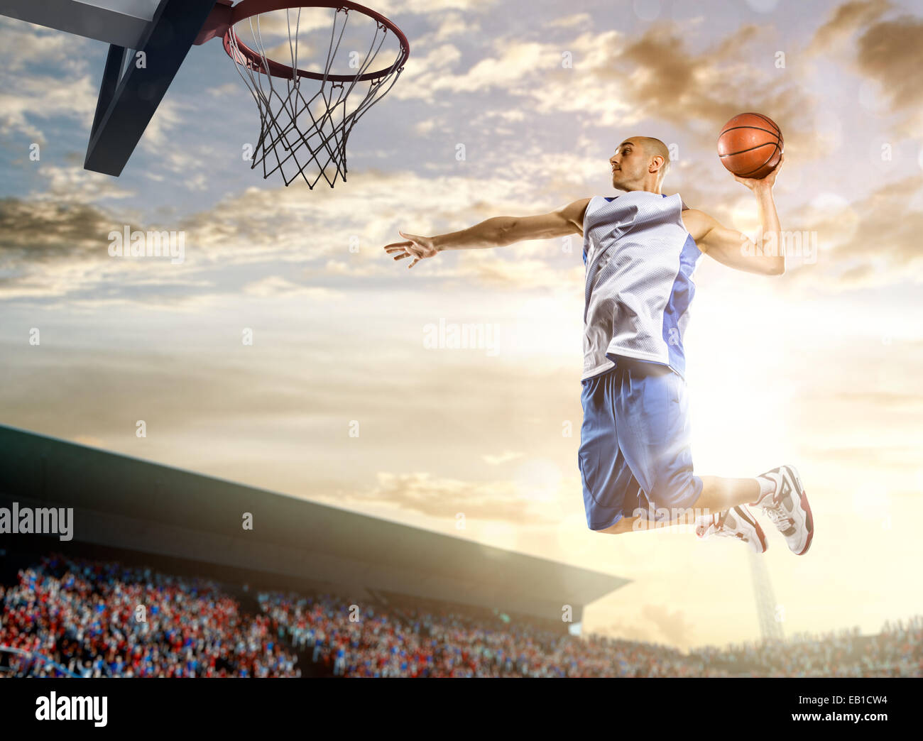 Basketball player in action on background of sky and crowd Stock Photo ...