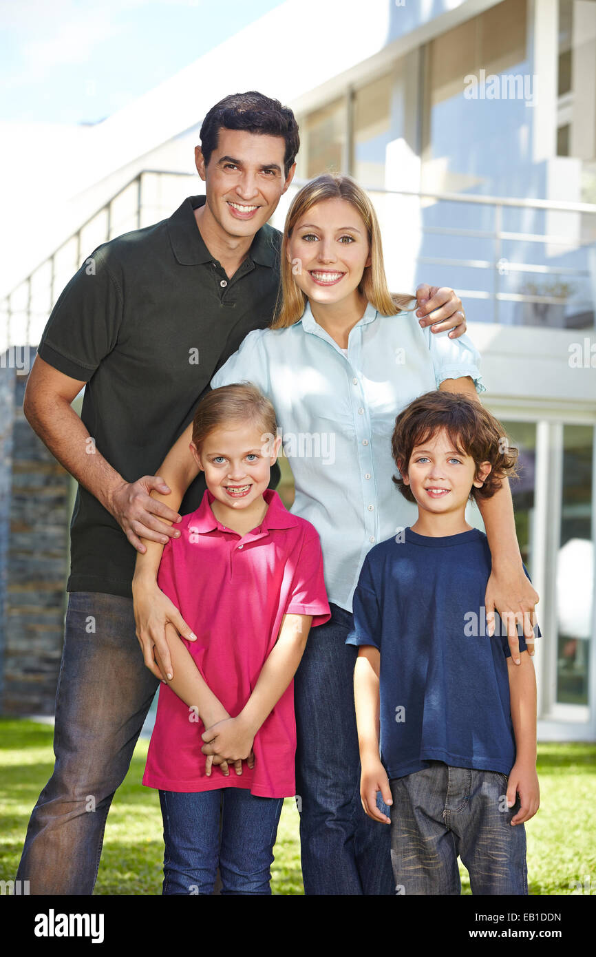 Portrait of a happy family with two children in front of a house Stock ...