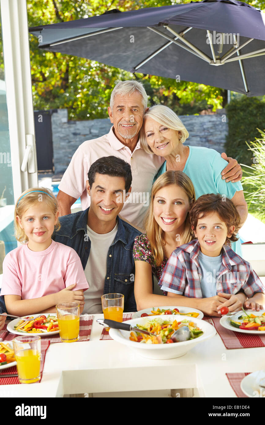 Happy vegetarian family eating healthy with salad at lunch Stock Photo ...