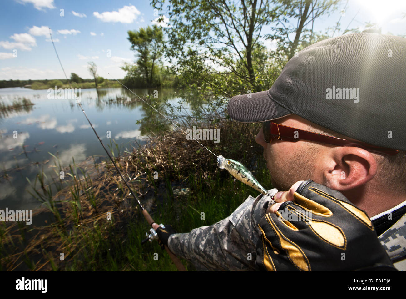 Angler in sunglasses is casting the top water lure Stock Photo - Alamy