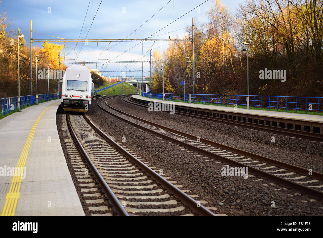 A city train arriving at a small railway station Stock Photo - Alamy
