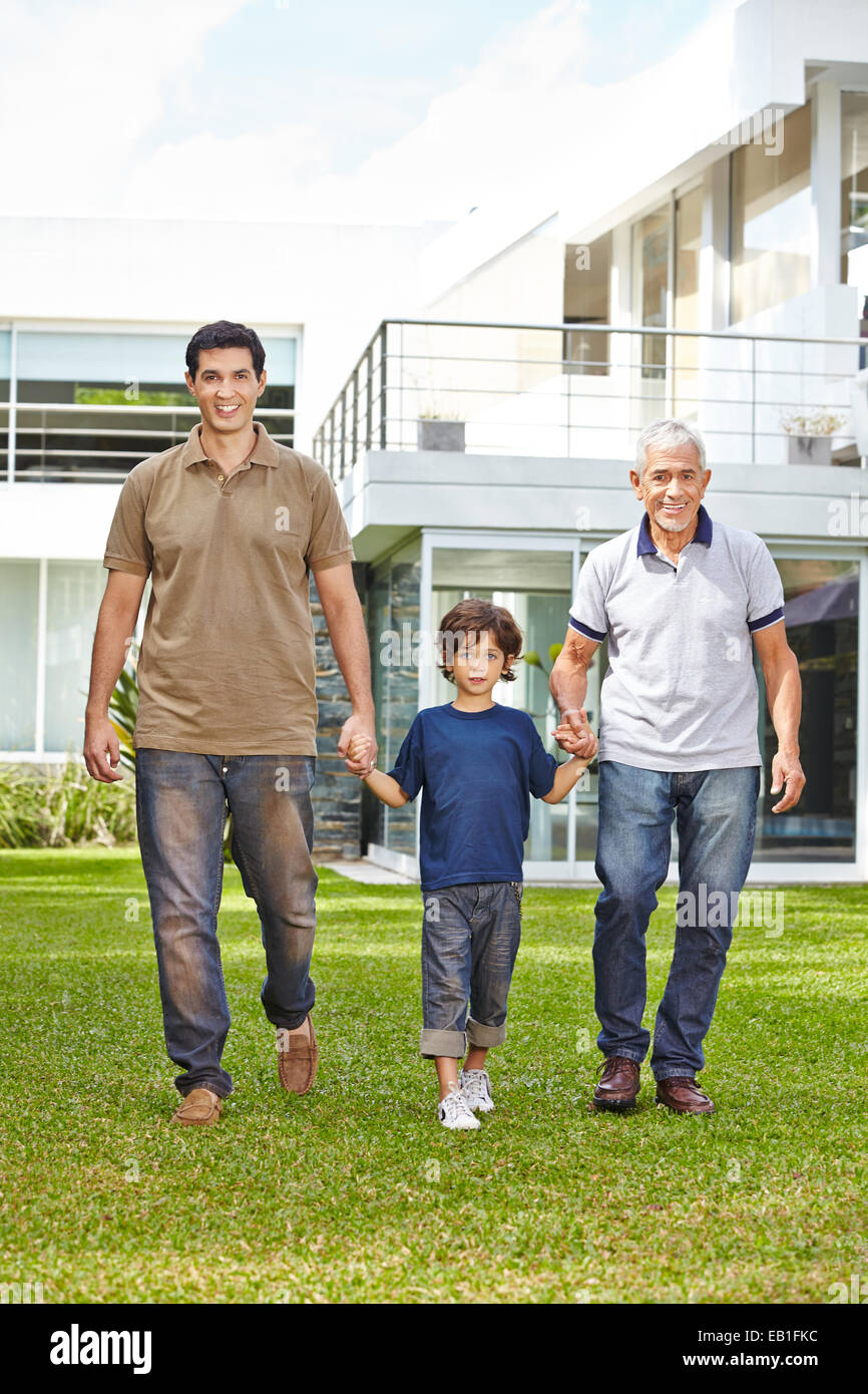Family in three generations in front of a modern house in summer Stock ...