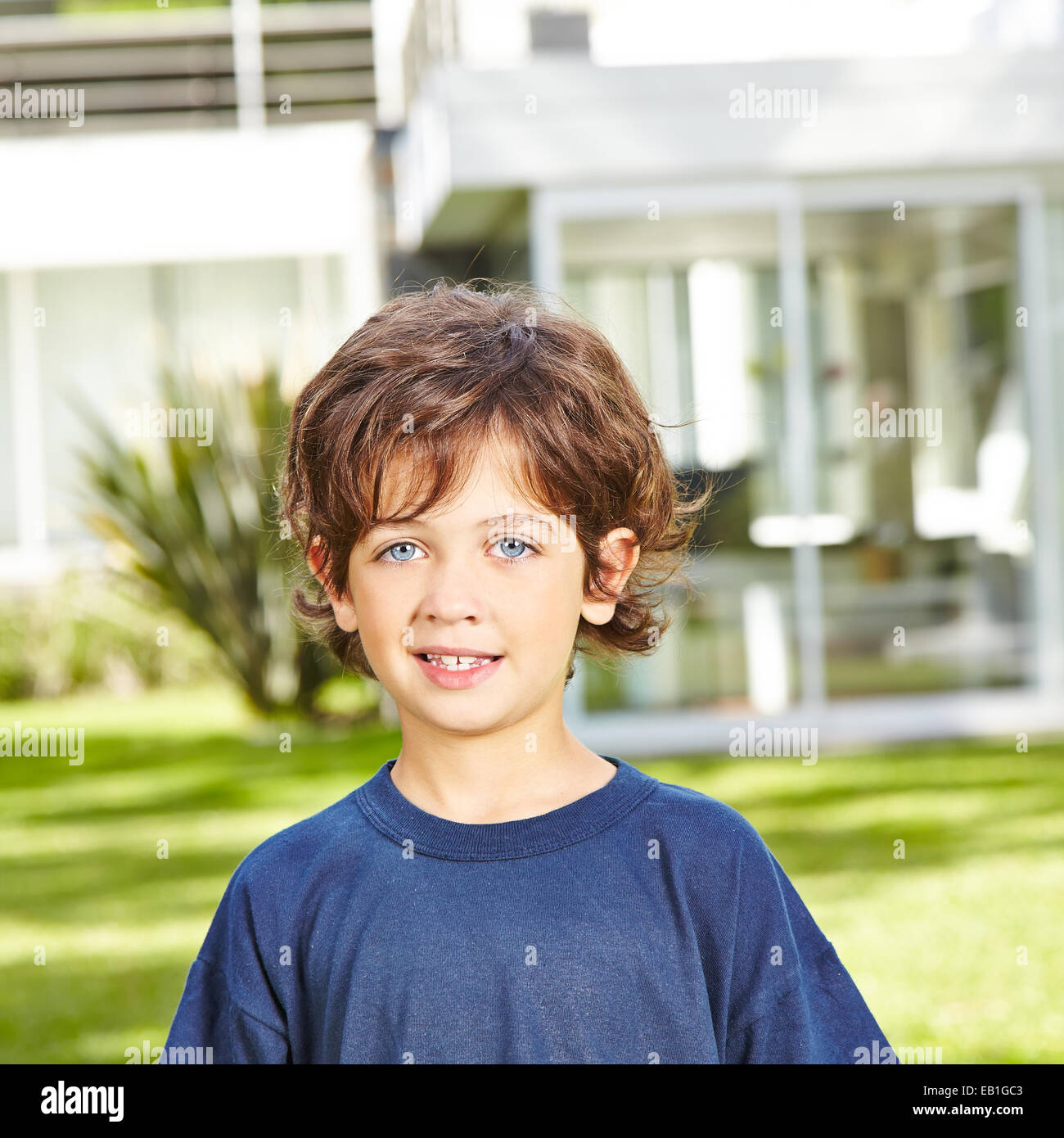 Happy boy standing smiling in a garden Stock Photo - Alamy
