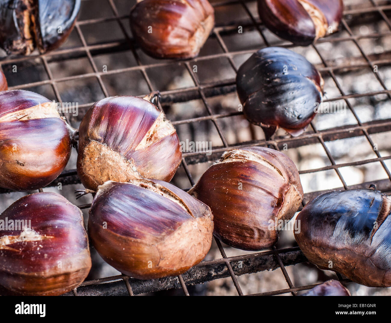 fresh chestnuts in a grill with fire charcoal Stock Photo - Alamy