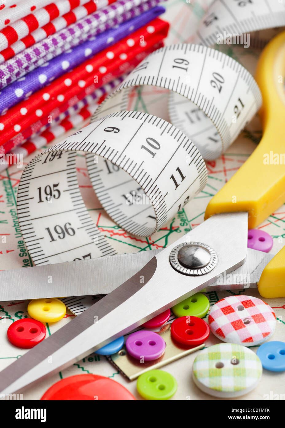 Sewing items: buttons, colorful fabrics, scissors, measuring tape ...