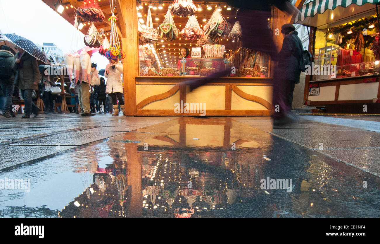 Berlin, Germany. 24th Nov, 2014. A man jumps over a puddle by a stand ...