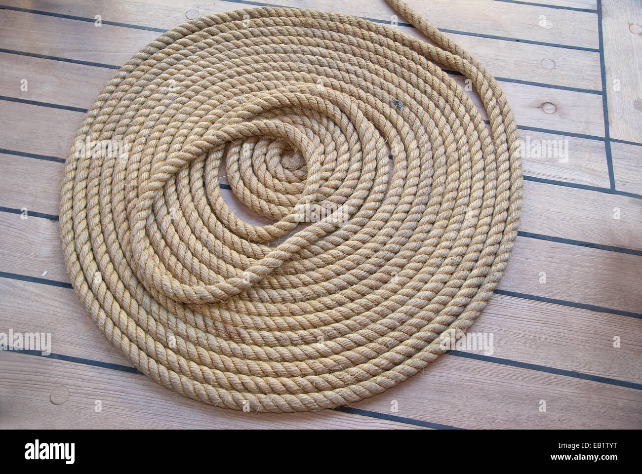 Circle bunch of ship rope on the wooden deck Stock Photo - Alamy