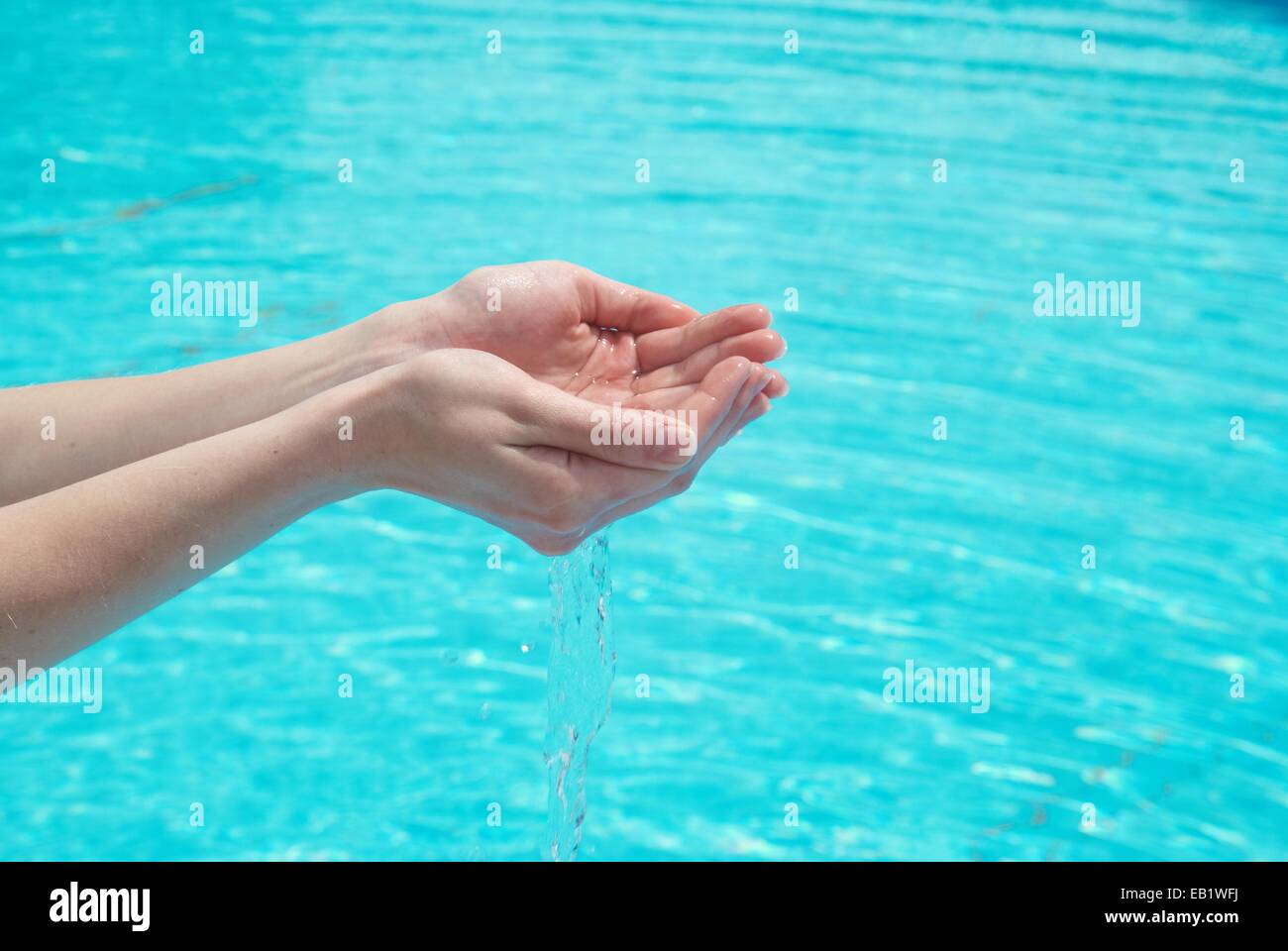 Human hands with clear water on the blue background Stock Photo - Alamy