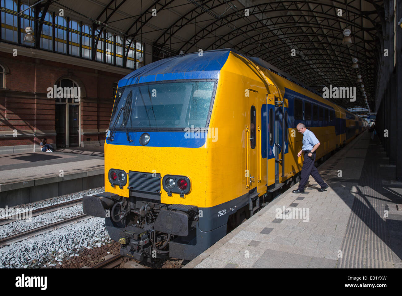 Conductor getting in a train ready to start at the train station of ...