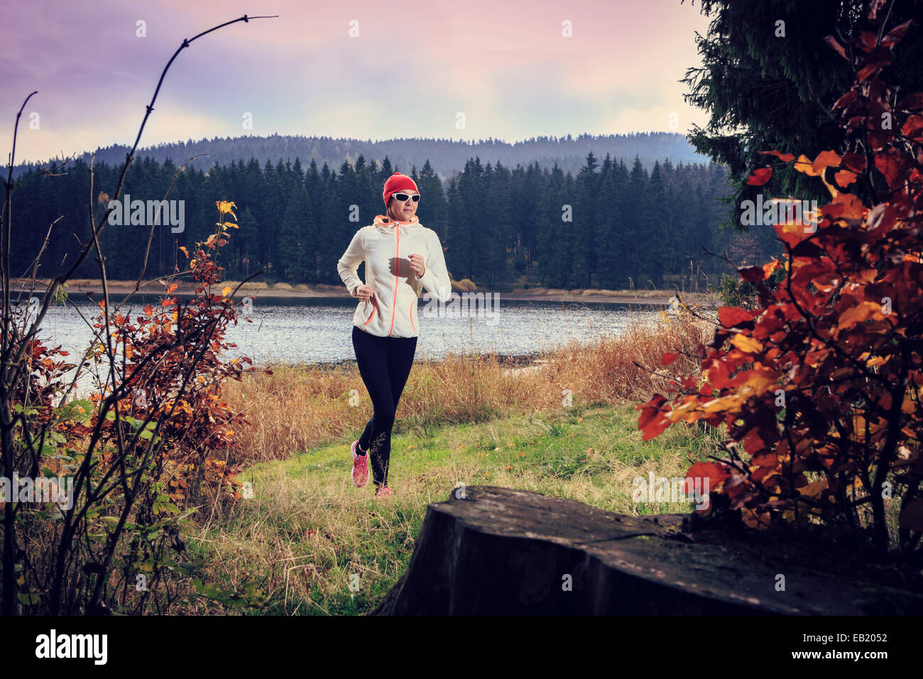 woman running through the forest by the lake Stock Photo - Alamy
