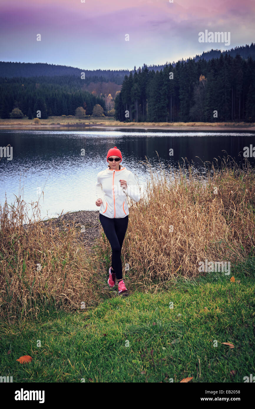 woman running through the forest by the lake Stock Photo - Alamy