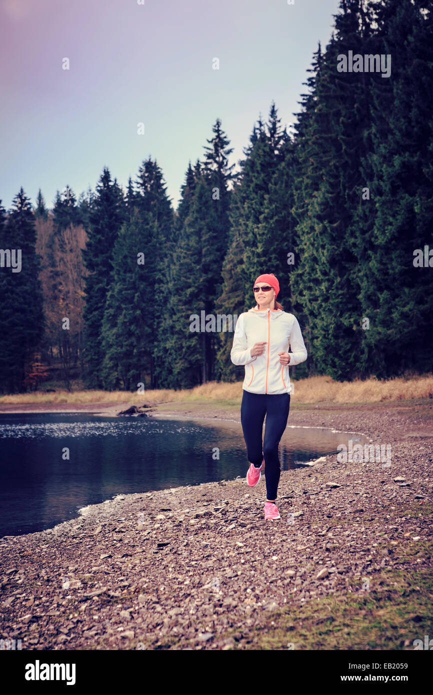 woman running through the forest by the lake Stock Photo - Alamy