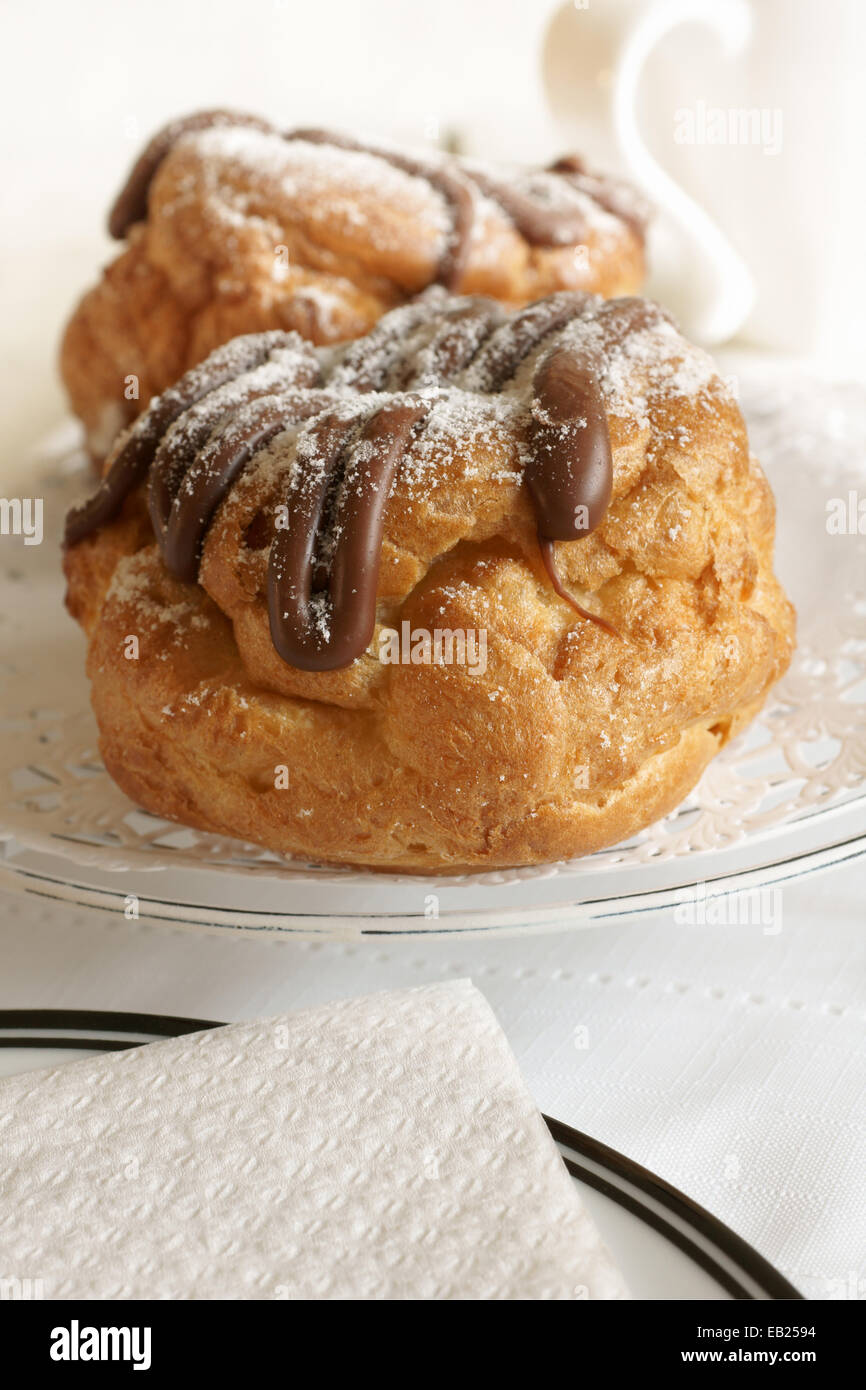 Choux buns filled with cream and drizzled with chocolate and icing ...