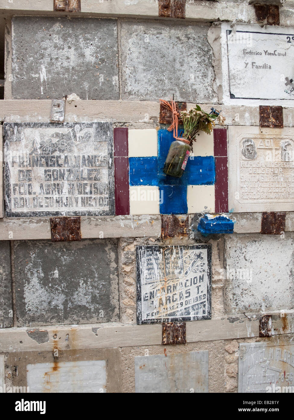 Close up of stacked graves, one with grave offering of flowers in a ...