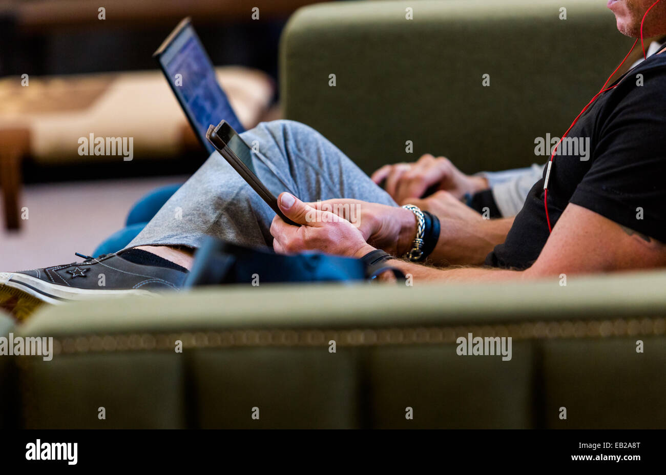 People reading on tablets while waiting for train Stock Photo - Alamy