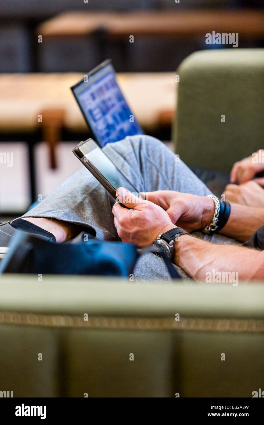 People reading on tablets while waiting for train Stock Photo - Alamy