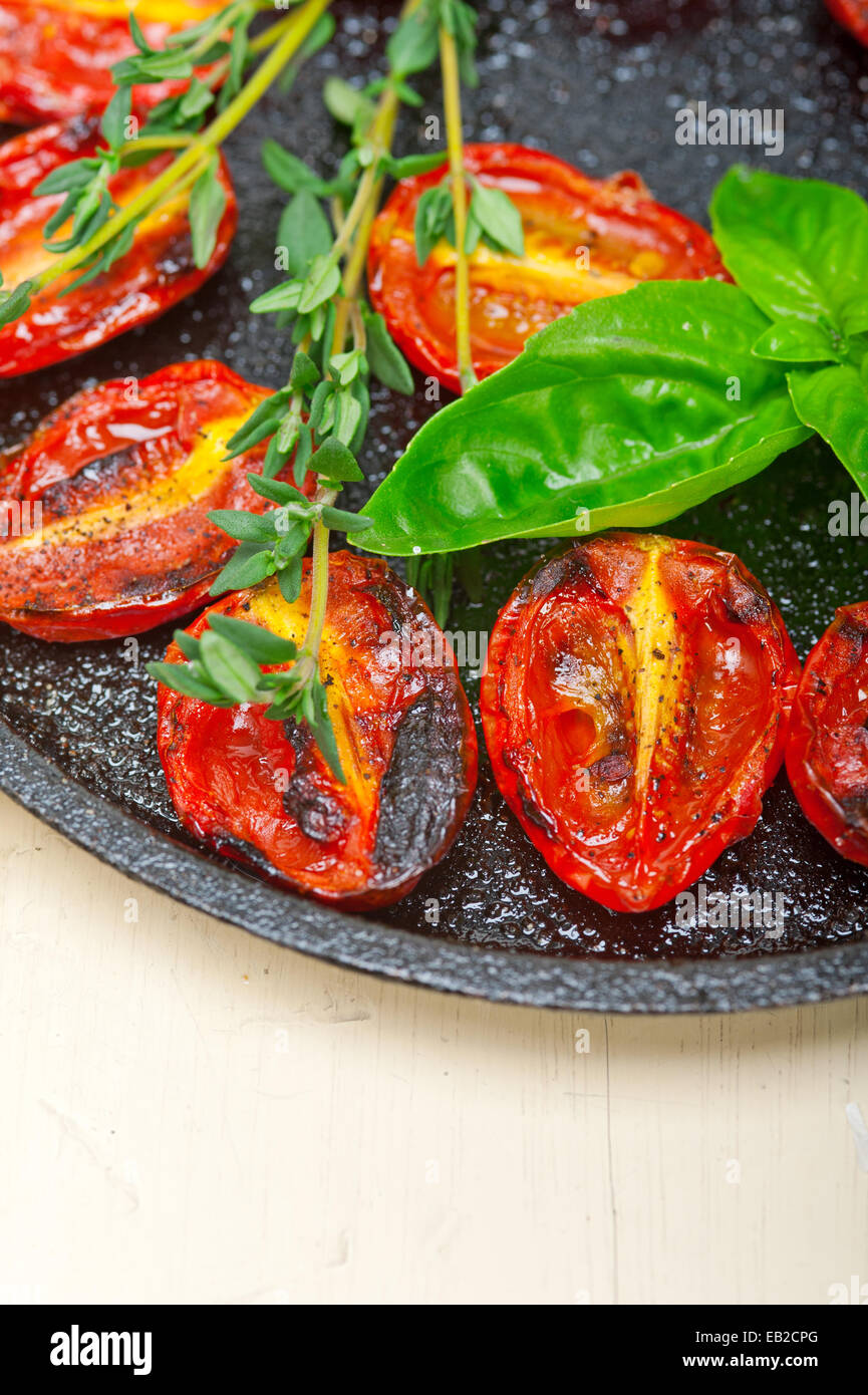 oven baked cherry tomatoes with basil and thyme on a cast iron skillet ...