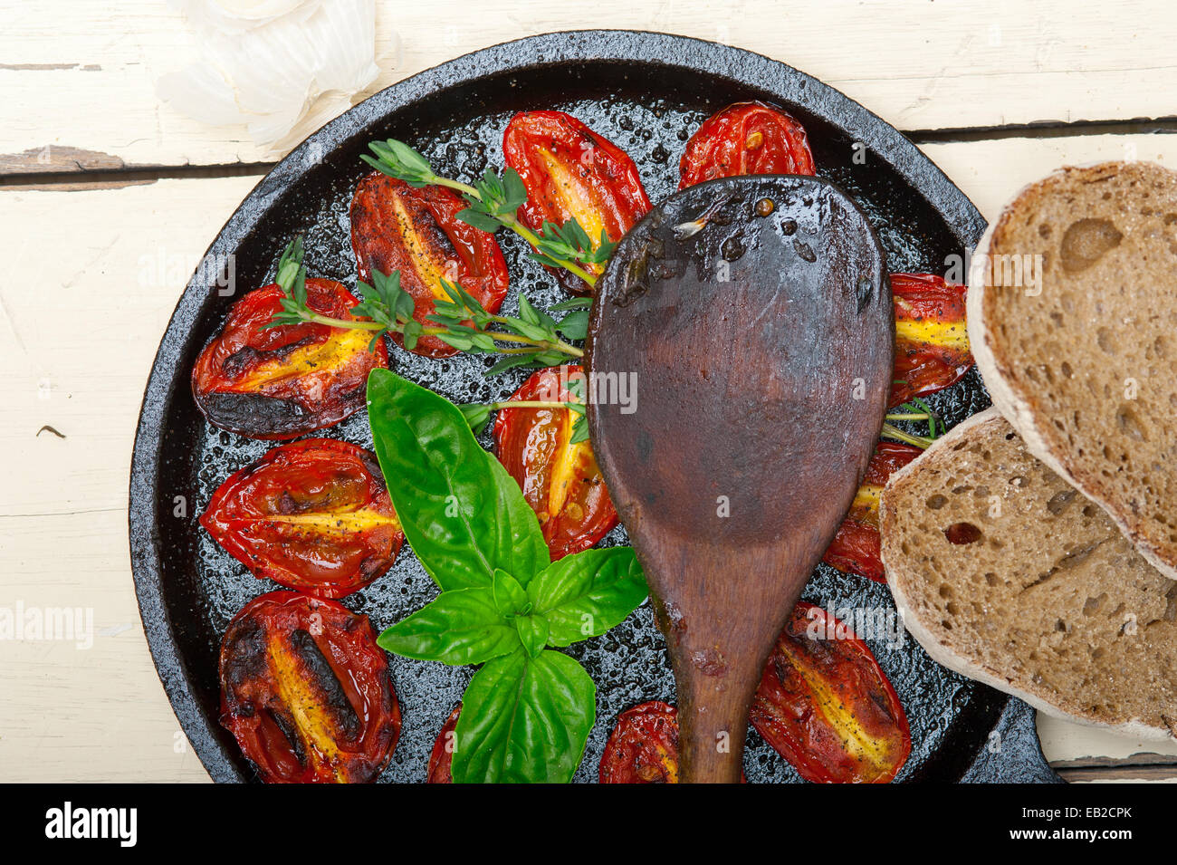 oven baked cherry tomatoes with basil and thyme on a cast iron skillet ...