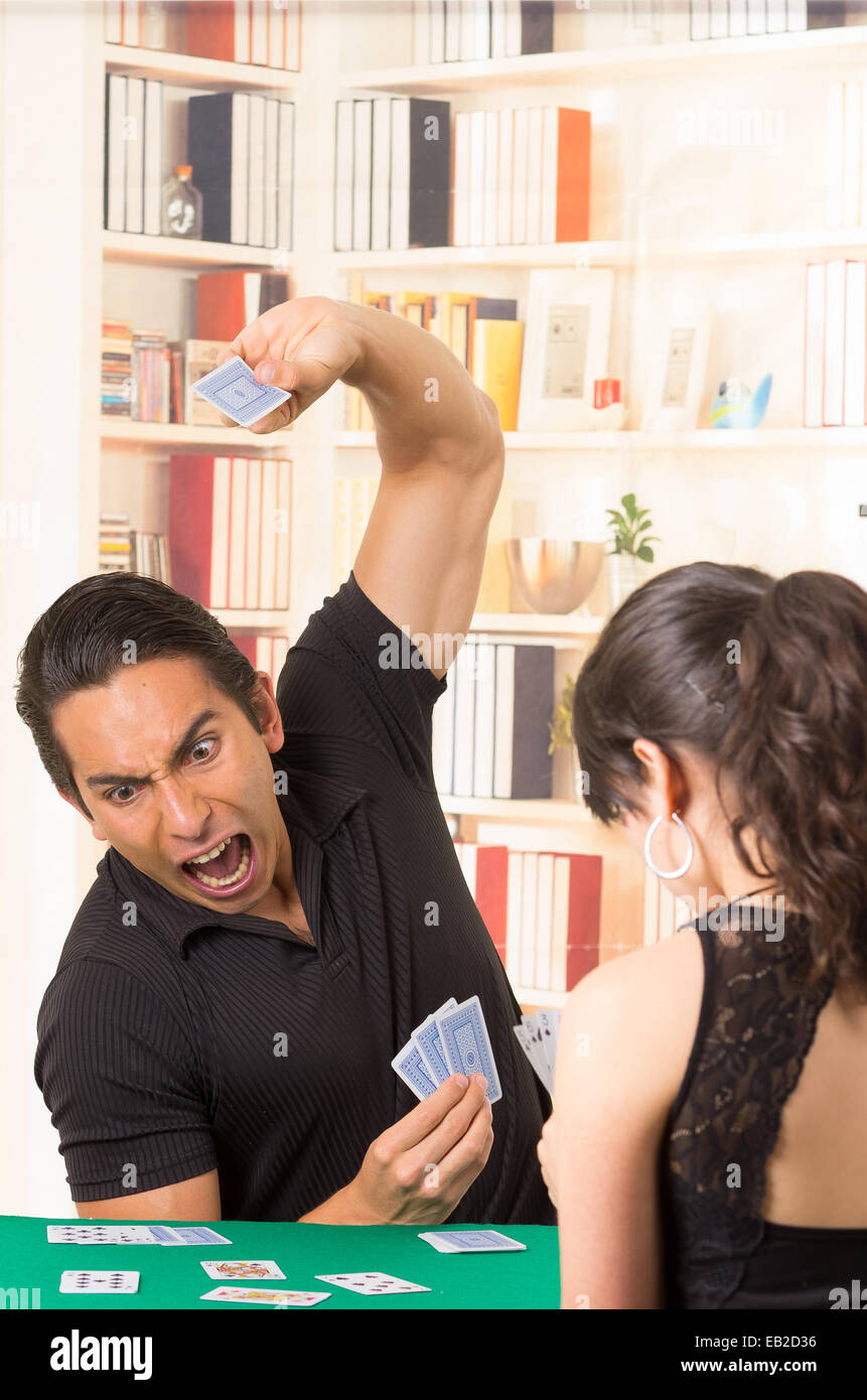 young couple playing cards cuarenta Stock Photo - Alamy