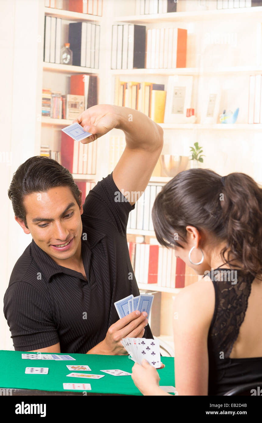 young couple playing cards cuarenta Stock Photo - Alamy