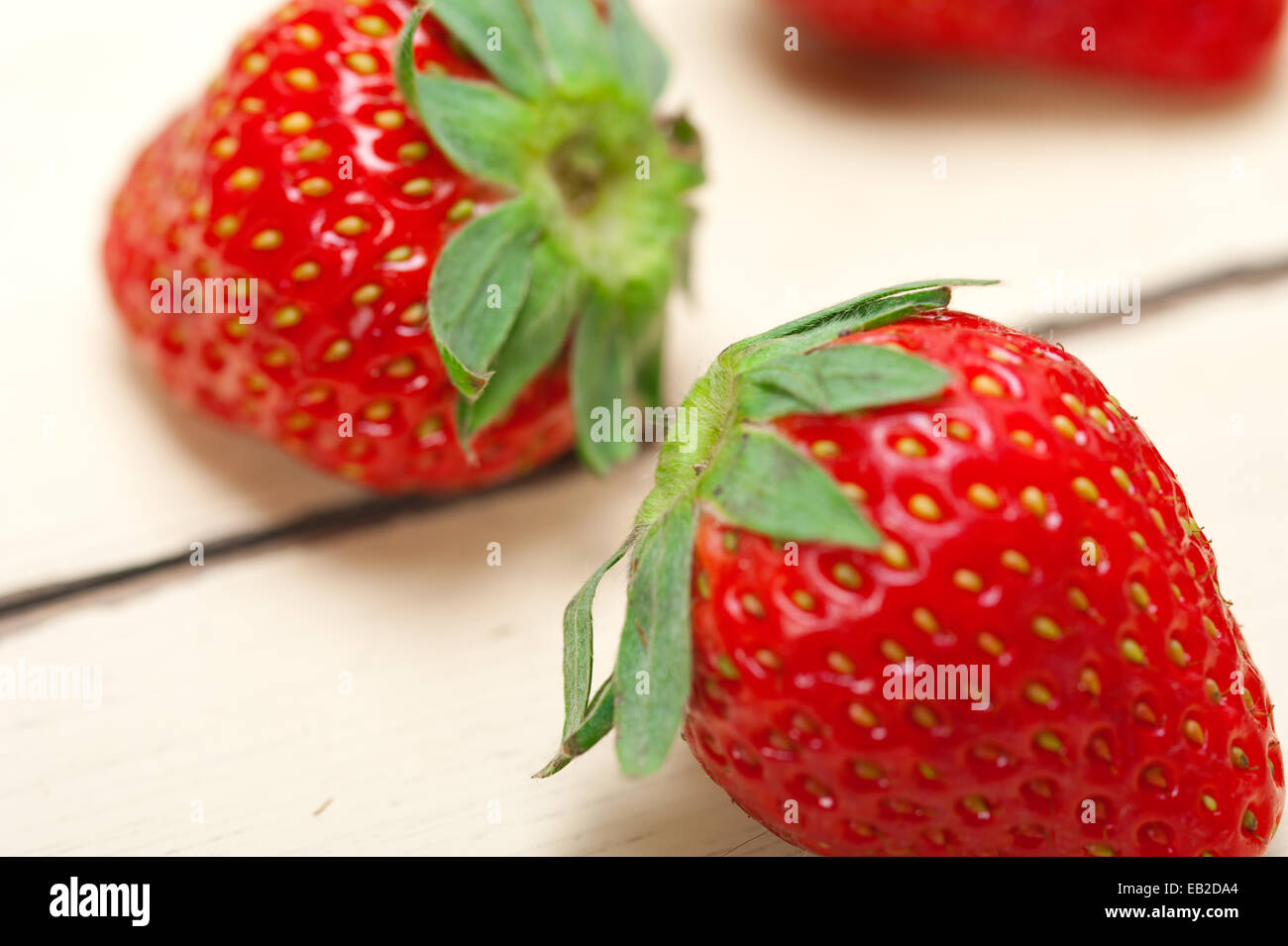 fresh organic strawberry over white rustic wood table Stock Photo - Alamy