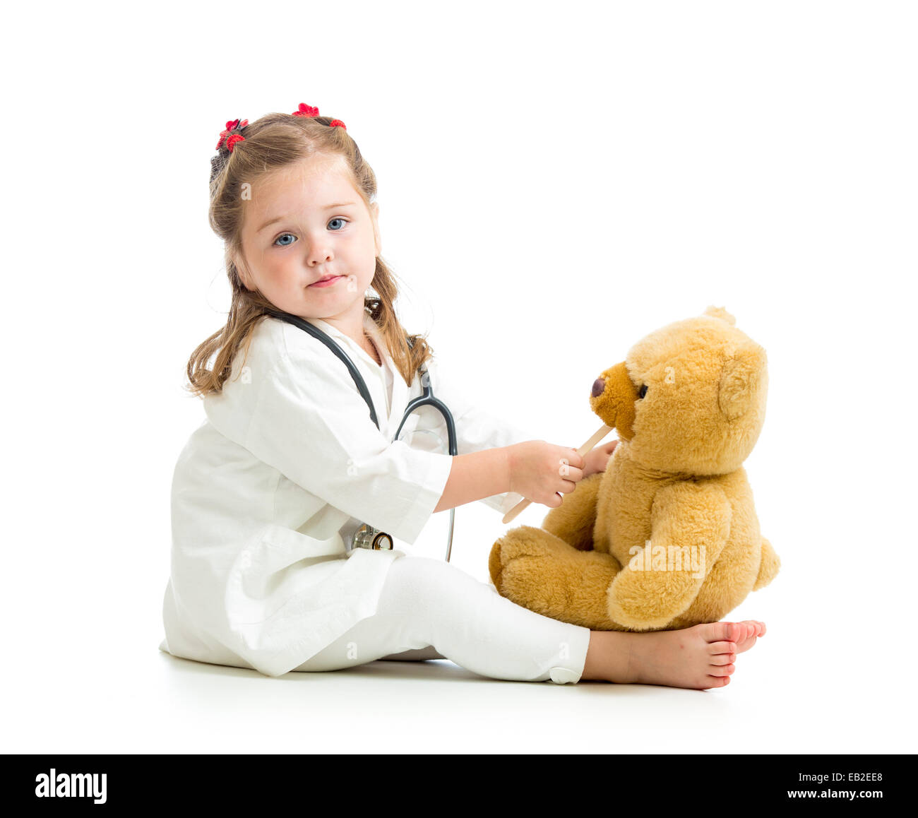 Adorable kid dressed as doctor playing with toy over white Stock Photo ...
