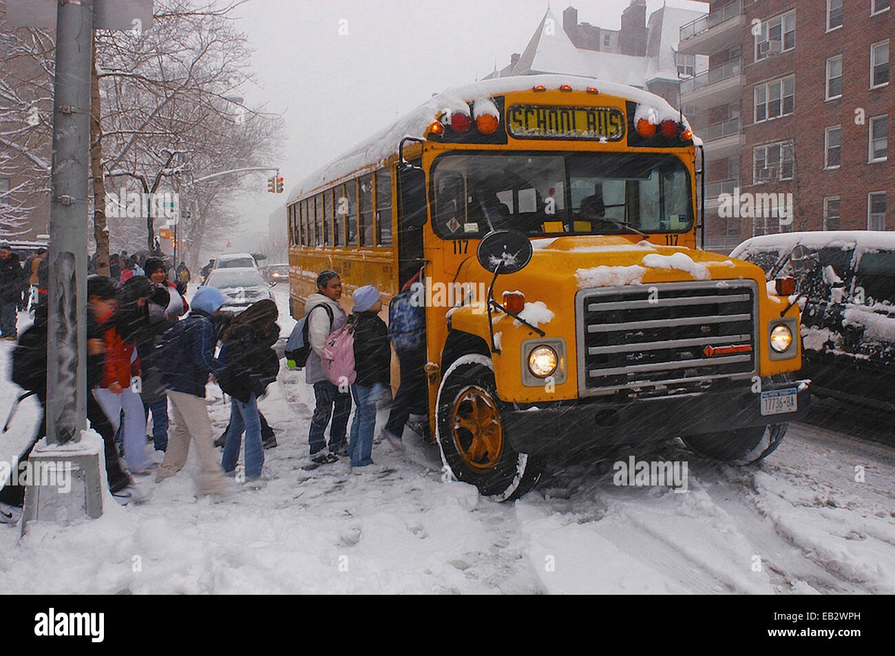 Kids getting into a yellow school bus in the snow in New York City ...