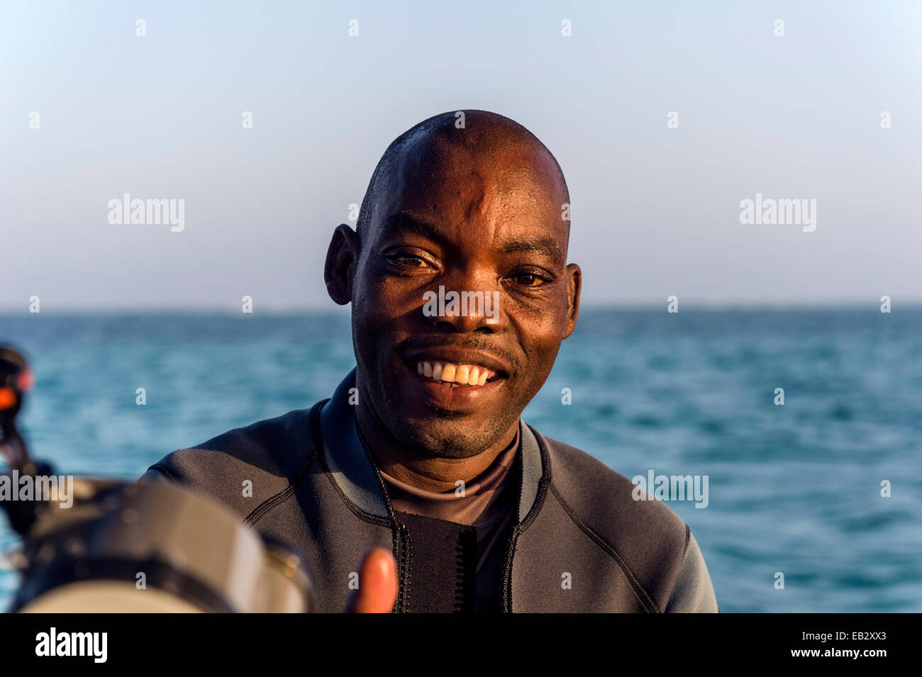 The smiling face of an African scuba diving Master on a boat in the ...